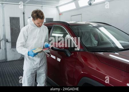 Auto colorist selects car paint color with samples Stock Photo - Alamy