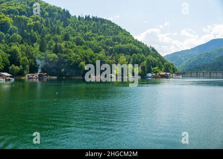Buildings on the shore of Lake Izvorul Muntelui on a sunny day, Lake ...