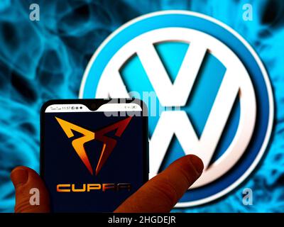 In this photo illustration, a Cupra logo is seen on a smartphone and in ...