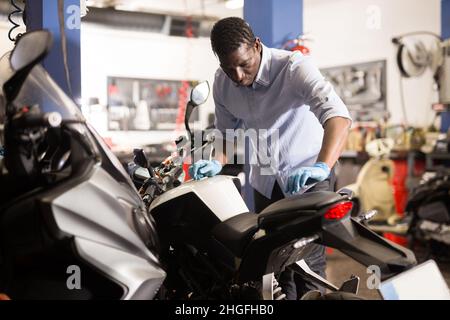 Mechanic is repairing modern moto in the workshop Stock Photo - Alamy