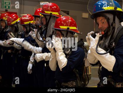 Recruits don firefighting equipment before a firefighting and damage ...