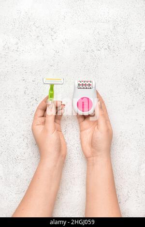 Female hands with modern epilator, razor and paper sticky notes with ...