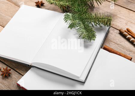 Opened books with blank pages and winter decor on wooden background ...