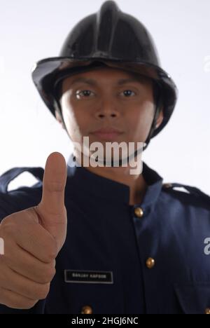A portrait of Asian male firefighter in red protective uniform, mask ...