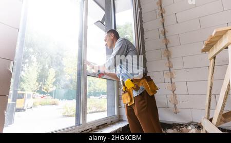 Construction worker installing window in house Stock Photo - Alamy