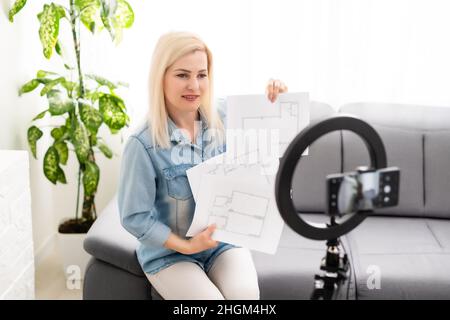 Calm clever woman standing in the bedroom in front of a camera on ...