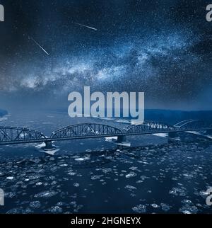 Milky way over frozen river and snowy forest in winter. Night sky in ...