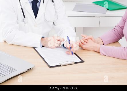 Doctor and patient are discussing something, just hands at the table ...