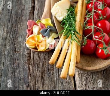 Tasty green pasta with pepper, and tomatoes on wooden table background ...