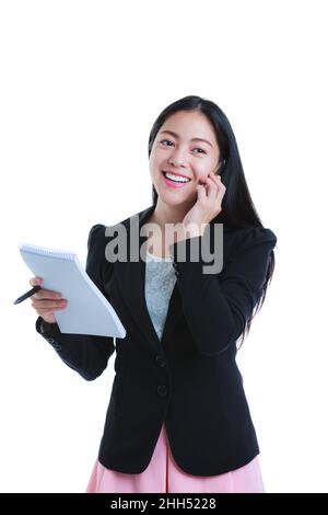 Vertical shot of a smartphone and a notepad on a yellow background ...
