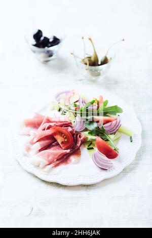 Plate of smoked ham with tomatoes and rocket. Close up Stock Photo - Alamy
