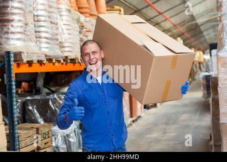 Warehouse worker carrying pasteboard box Stock Photo - Alamy