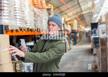 Storekeeper using his phone to take photograph of pasteboard box Stock ...