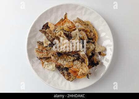 Deep-fried yellow pollack peel on a white background Stock Photo - Alamy