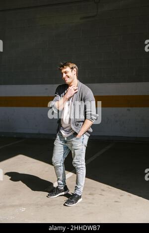 Vertical shot of a handsome European male in a black leather jacket ...