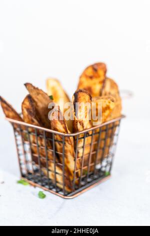 Freshly baked potato wedges with spices in a wire basket Stock Photo ...
