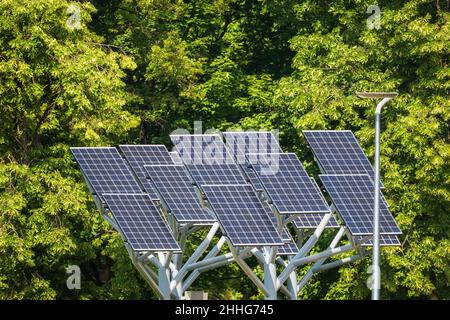 Solar panels stand against green mountains and blue sky at a ...