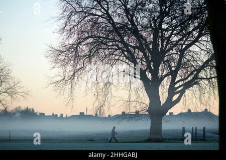 A pedestrian is seen walking through the mist in a park in Ilford, East ...
