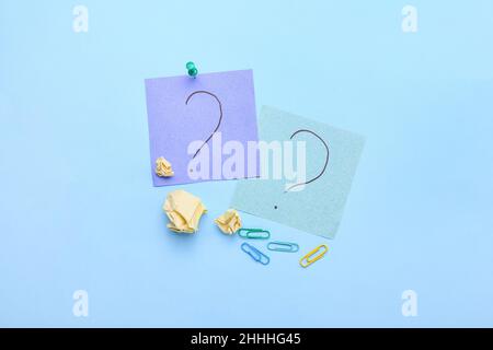 Paper sticks with question marks and clips on blue background Stock ...