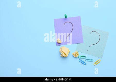 Paper sticks with question marks and clips on blue background Stock ...