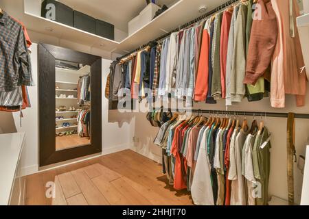 Interior wardrobe or dressing room with rows of clothes and shelves ...