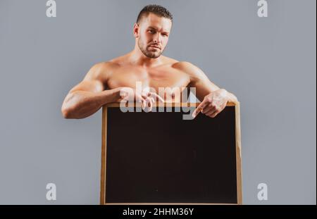 Handsome bodybuilder man with sign advertising board. Strong muscular ...