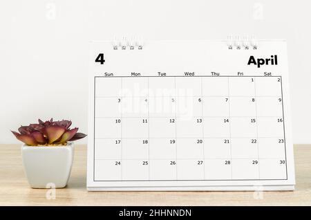 The April 2022 desk calendar with plant on wooden table Stock Photo - Alamy