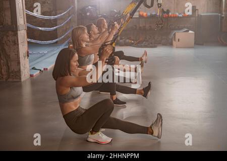 Athletic people doing crossfit training with trx straps Stock Photo - Alamy