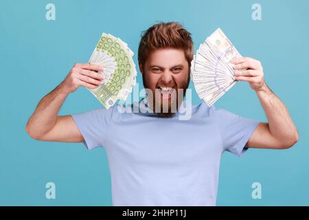 Amazed and happy man holding credit card, looking at money satisfied ...