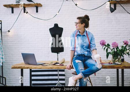 Mannequin, sitting on table with legs extended wearing black nylons and ...