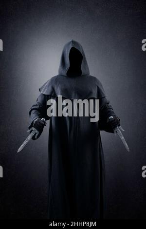 Hooded assassin with two daggers in the dark Stock Photo - Alamy