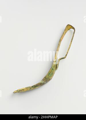 A bronze strigil, Roman, 3rd century A.D. A curved scraper with a ...