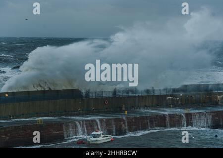 Waves crash over Dunbar harbour walls as the East coast of Scotland is ...