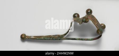 The bronze fibula, an ancient safety pin with four rings, is a ...