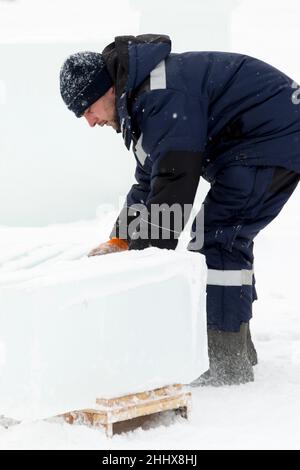 Man loading ice panels onto wooden sled Stock Photo - Alamy