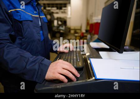 Technician typing keyboard garage Stock Photo - Alamy