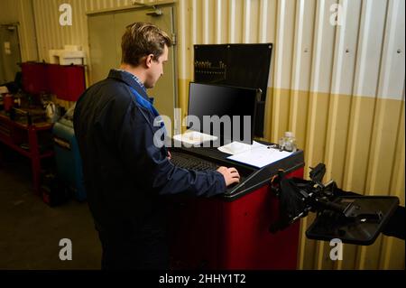 Technician typing keyboard garage Stock Photo - Alamy