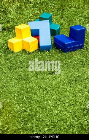 Soft colorful huge tetris cubes on green lawn. Outdoor teambuilding ...