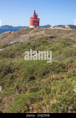 Beautiful view of a Punta Robaleira red lighthouse in Donon, Spain with ...