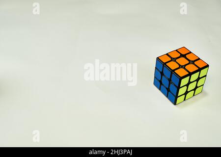 solved rubik's cube in blue, yellow and orange on white background ...