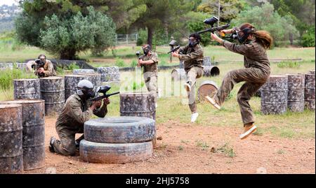 Group of friends paintball players of opposite teams in shootout in ...