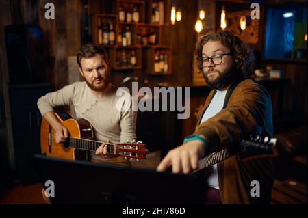 Teacher giving guitar lesson to young guy Stock Photo - Alamy