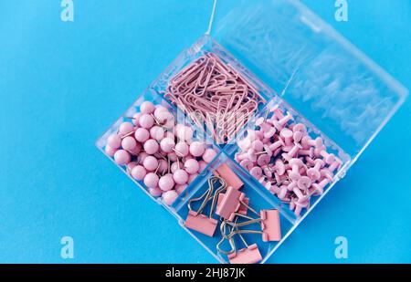 pins and clips in plastic pox on blue background Stock Photo - Alamy