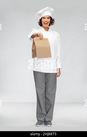 happy female chef with takeaway food in paper bag Stock Photo - Alamy