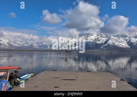 A Boatman rests in his boat on a sunny winter day in Dal lake, Srinagar ...