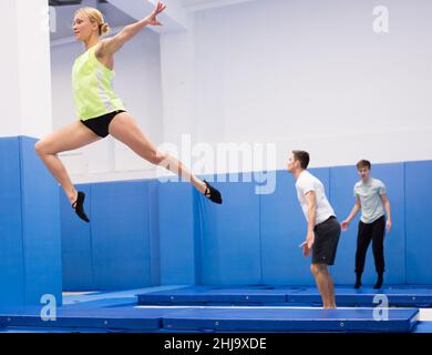 Female gymnast jumping on trampoline Stock Photo - Alamy