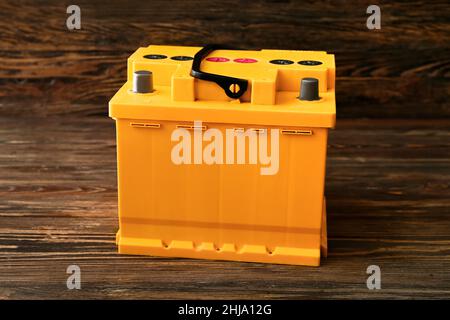 Modern car battery on wooden background Stock Photo - Alamy