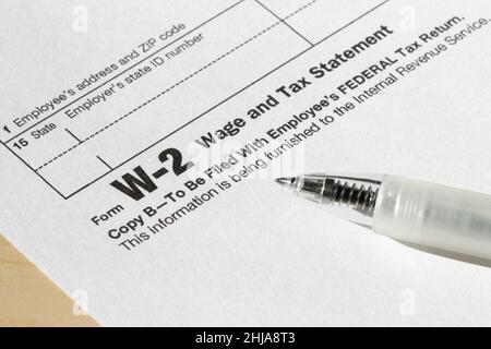 IRS form W-2 wage and tax statement lies on flat lay office table and ...