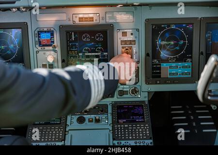 Airline pilot using instrument panel in aircraft cockpit Stock Photo ...