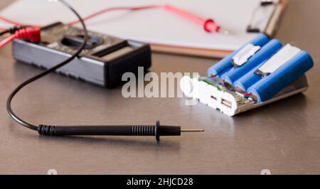 black polymeter work table. in the background multimeter and powerbank ...